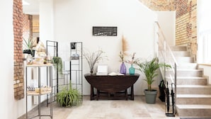 Um interior moderno com escada, um banco de madeira e diversas plantas.