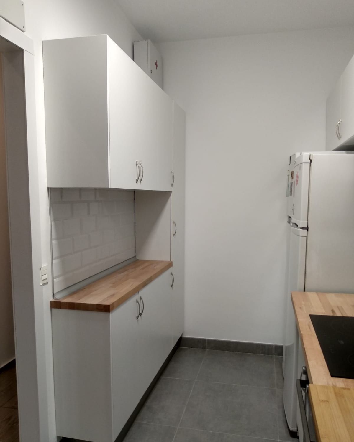 Um micro-ondas, um forno, uma placa de cozinha, uma cafeteira/bule 