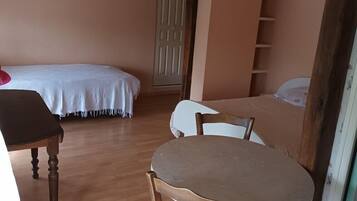 Quarto com duas camas, uma mesa e uma cadeira.