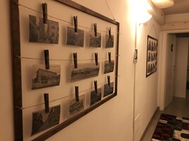 Um corredor com exposição de fotos presa à parede usando prendedores de roupa.