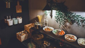 Cozinha com diversos alimentos e utensílios, incluindo uma tábua de corte, panelas e um relógio na parede.