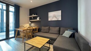 Uma sala de estar moderna com sofá, mesa de centro e área de jantar com cadeiras e mesa.