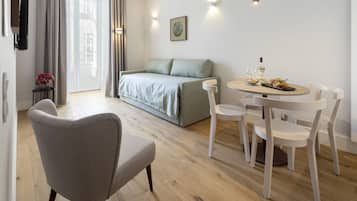 Apartamento superior, 1 quarto | Área de estar | TV de tela plana