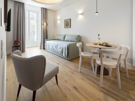 Apartamento superior, 1 quarto | Área de estar | TV de tela plana 24 polegadas com canais a cabo, TV