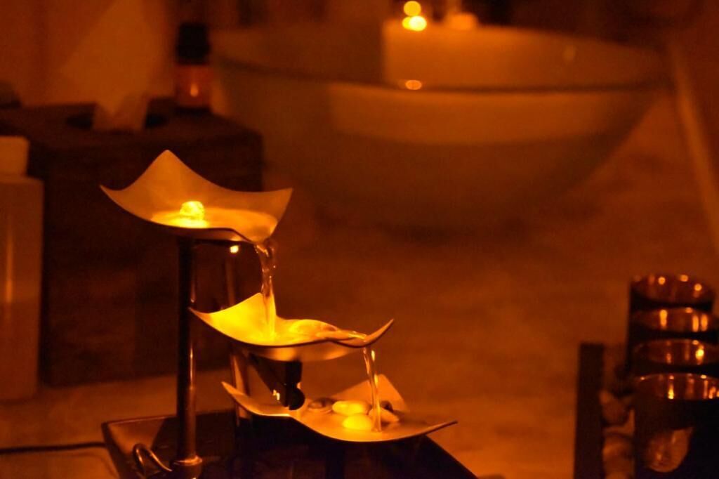 Casa de banho com lavatório e castiçal com vela acesa.