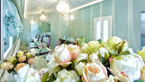Um quarto com uma mesa de jantar posta para refeição, um candelabro e um espelho refletindo o ambiente.