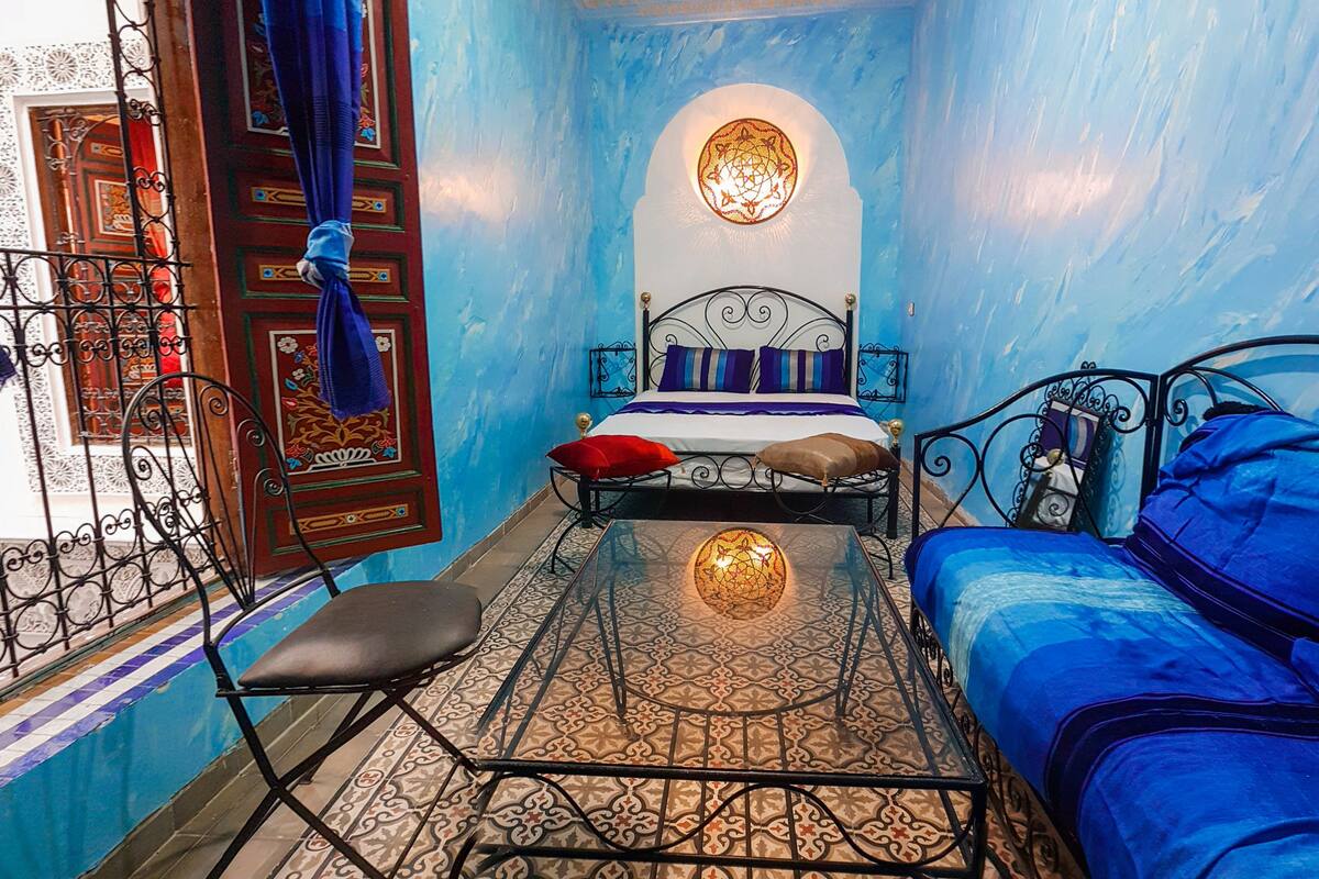 Um quarto com uma cama, um sofá, uma mesinha e uma cadeira.