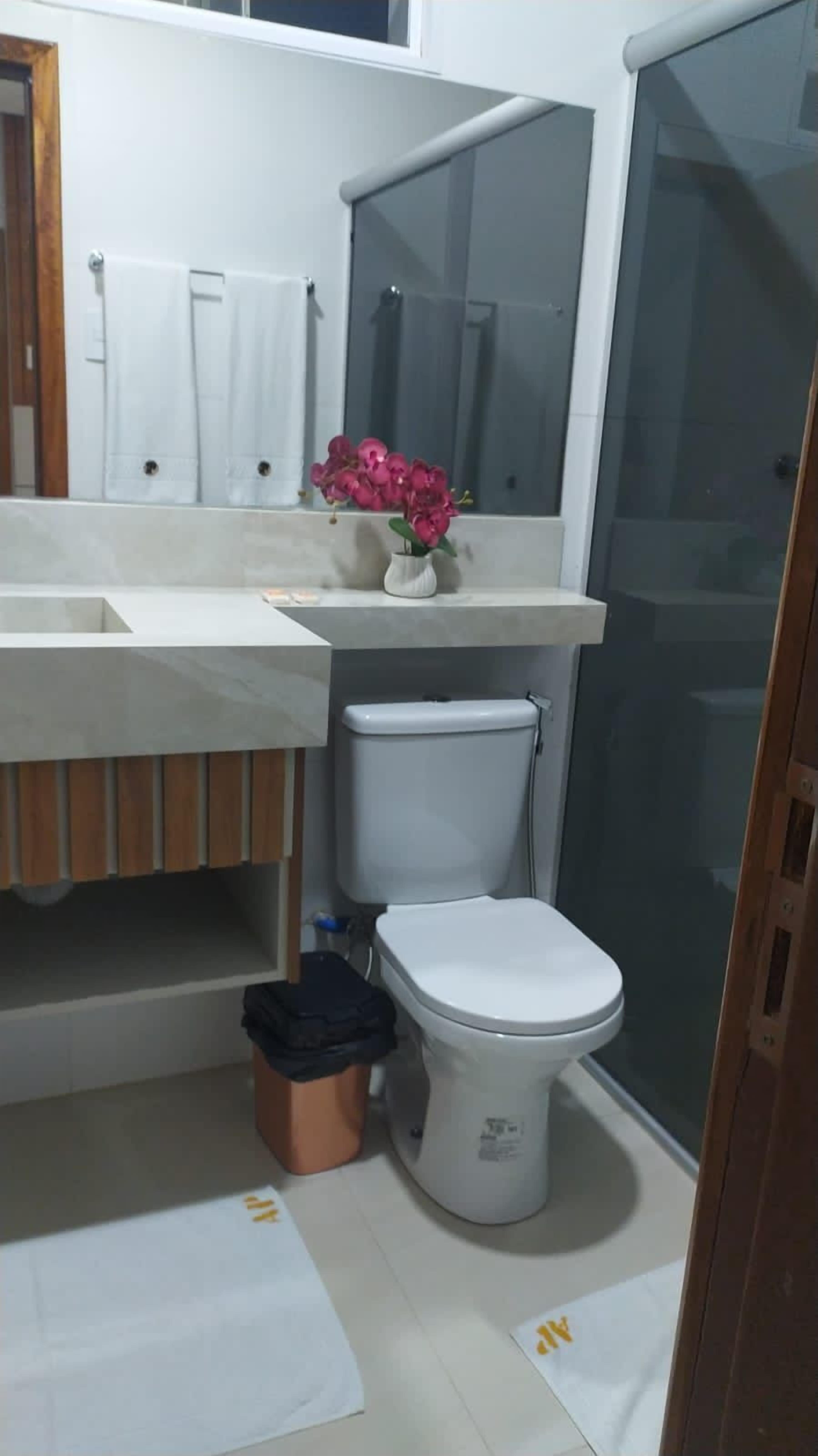 Um banheiro compacto com vaso sanitário, pia e espelho.