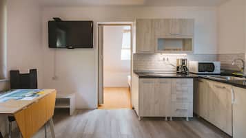 Apartamento, 1 quarto, vista para o jardim | Cozinha privada | Geladeira, micro-ondas, cooktop, cafeteira/chaleira