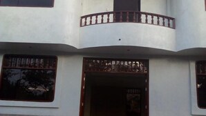 Um edifício de dois andares com varanda no andar superior.