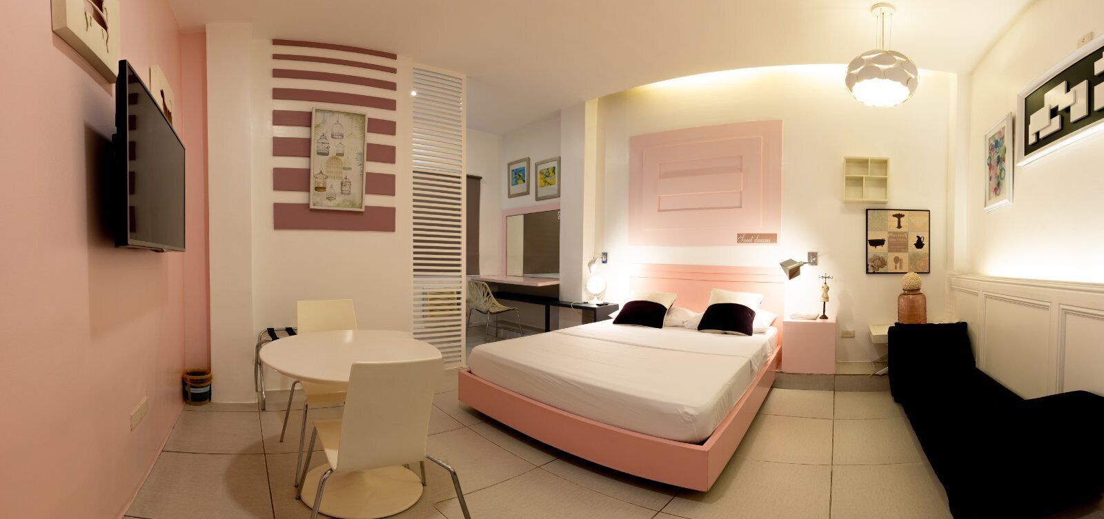 Quarto moderno com cama, mesa de cabeceira, poltrona e escrivaninha com cadeira.