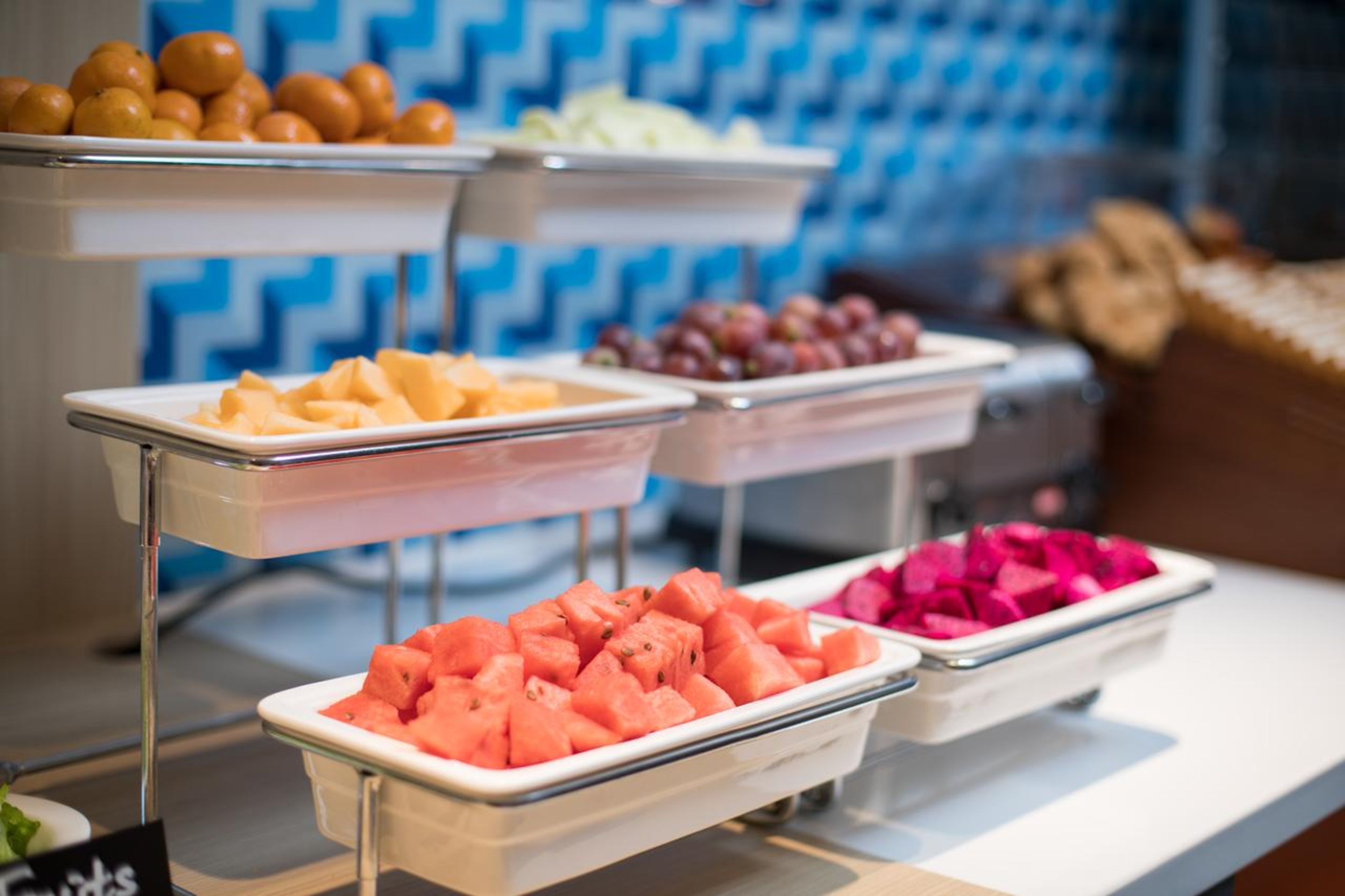 Um buffet com diversas frutas e um bolo sobre uma mesa.