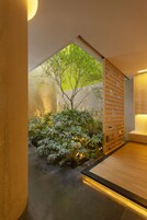 Decoração moderna com vista para um jardim, um banco de madeira e um painel com padrão treliçado.