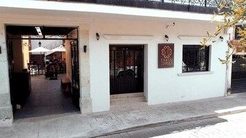 Entrada de um edifício com um portão preto, uma placa com a inscrição 'SANTO TOMAS' e uma escadaria que leva a um andar superior.
