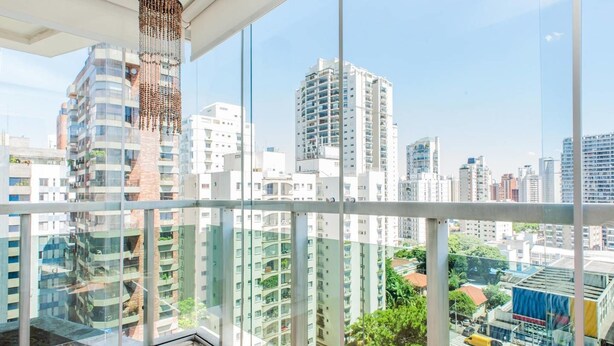 Apartamento alto com grandes janelas e vista para a cidade.