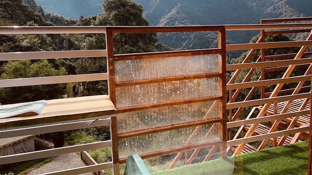 Uma varanda de madeira com vista para uma paisagem montanhosa.