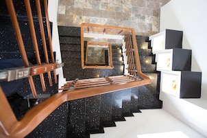 Uma escadaria moderna com corrimão de madeira e degraus pretos.