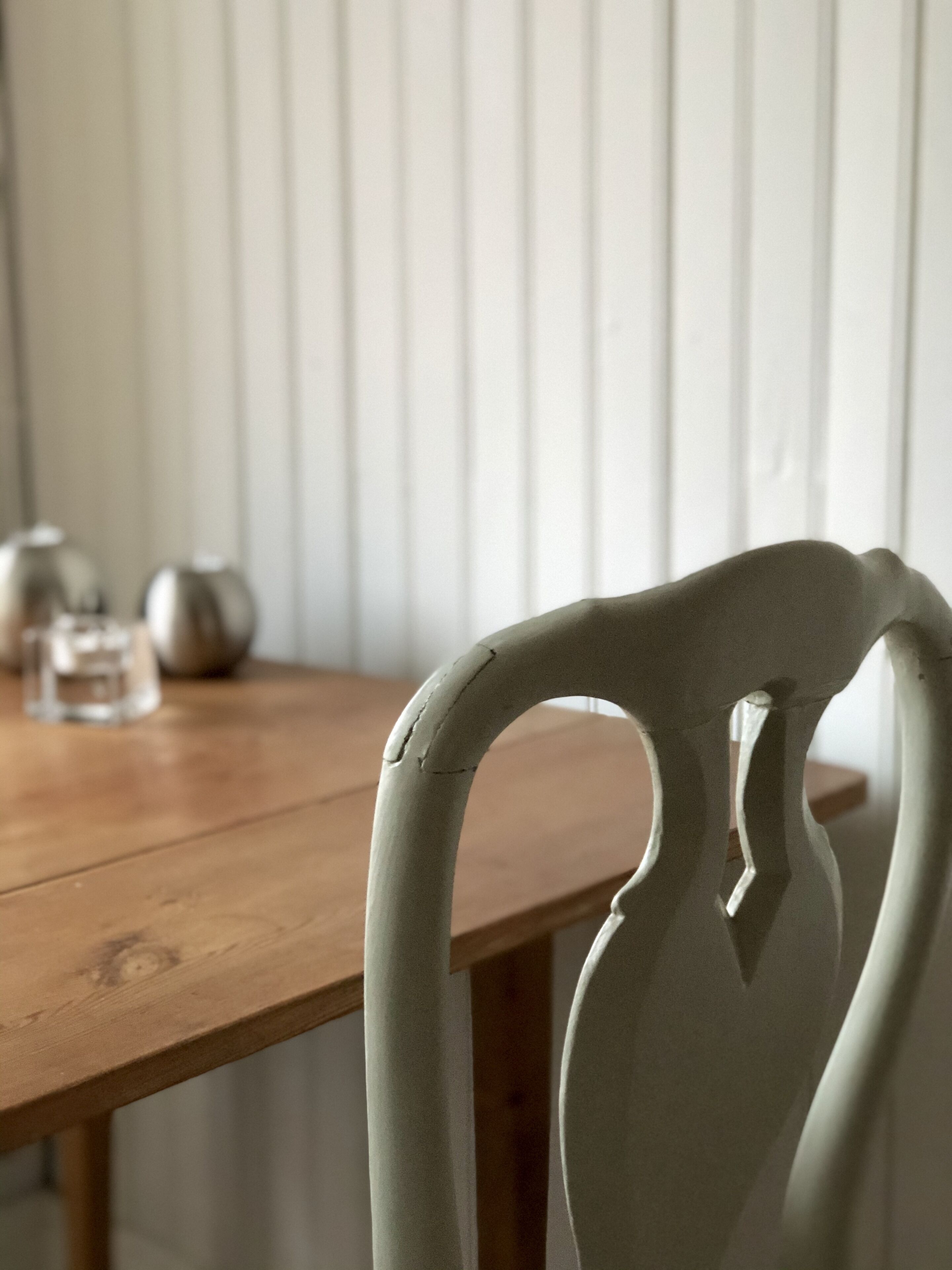 Uma mesa de madeira com uma cadeira branca à frente.