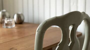 Uma mesa de madeira com uma cadeira branca à frente.