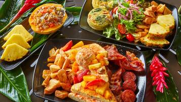 Diversos pratos, incluindo plantains fritos, uma salada com alface e tomate, e um prato com plantains fritos e carne.
