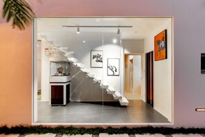 Interior moderno com escada, obras de arte emolduradas e design minimalista.