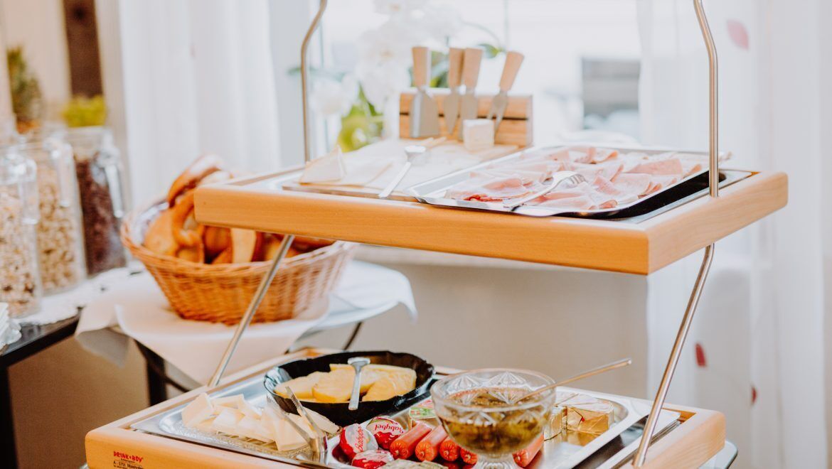 Disposição de buffet com diversos alimentos e utensílios.