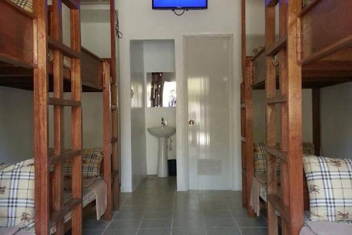 Um quarto com uma cama, pia e espelho.