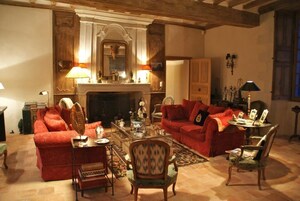 Uma sala de estar aconchegante com lareira, sofás vermelhos e uma mesa de centro.