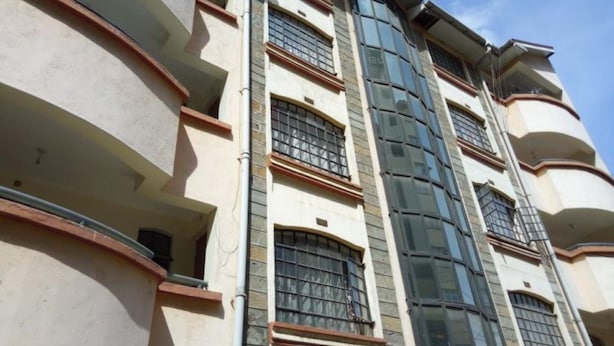 Um edifício de vários andares com varandas, grandes janelas e um design arquitetônico curvilíneo.