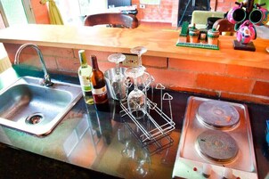 Uma cozinha com pia, uma garrafa de vinho e um suporte para copos de vinho.
