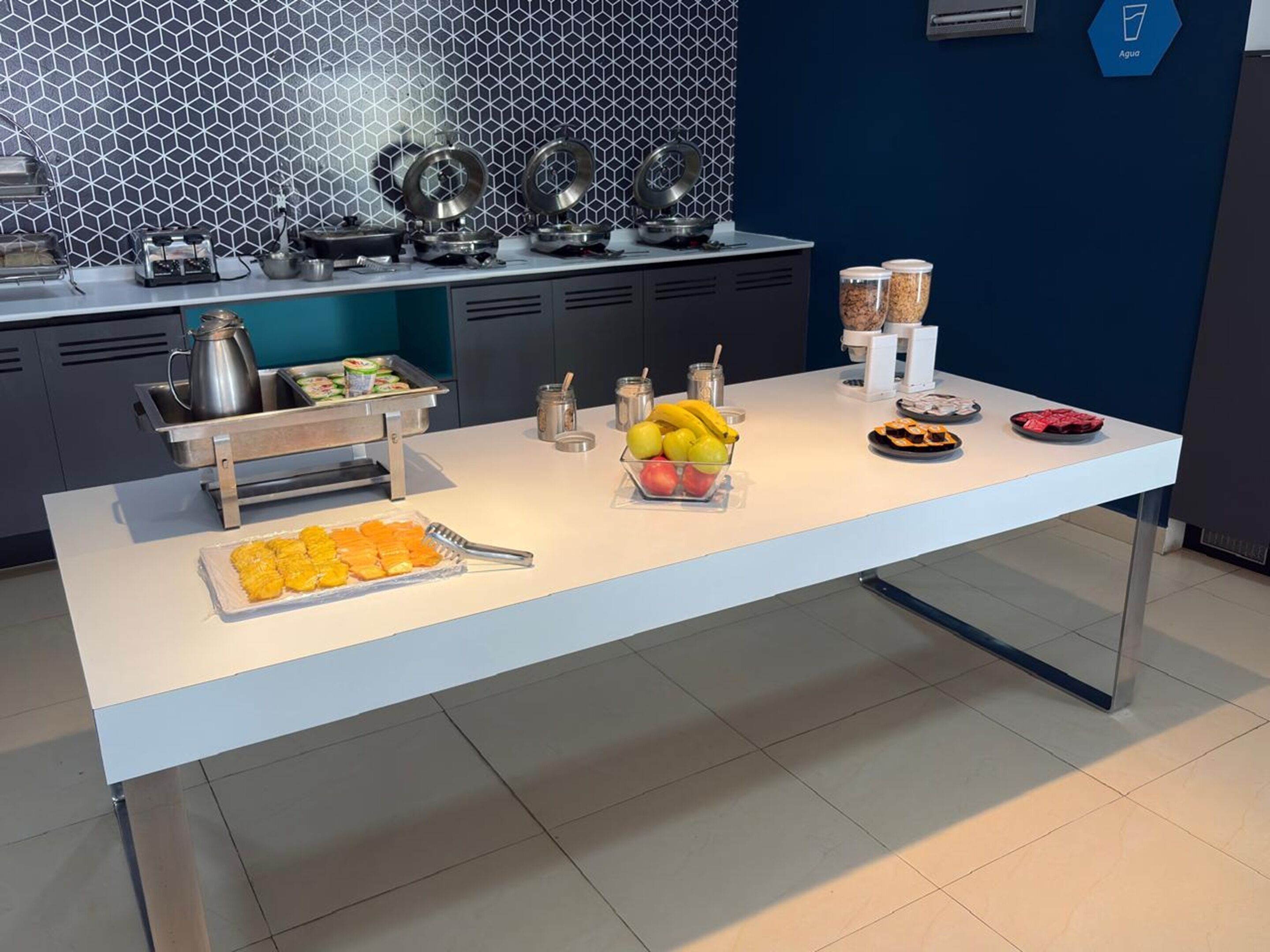 Disposição de buffet com diversos alimentos e utensílios de servir.