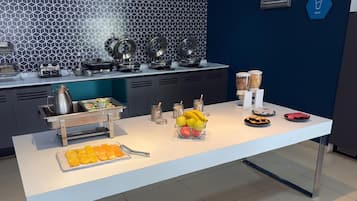 Disposição de buffet com diversos alimentos e utensílios de servir.