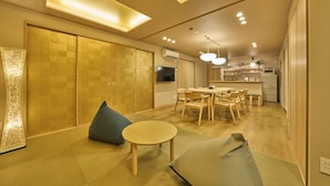 Um interior moderno com área de jantar, cozinha e espaço para sentar.
