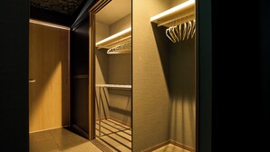 Um closet amplo com porta de madeira, cabideiro e prateleira.