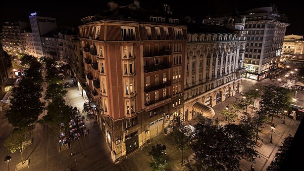Um edifício histórico com vários andares, janelas amplas e um pátio central.