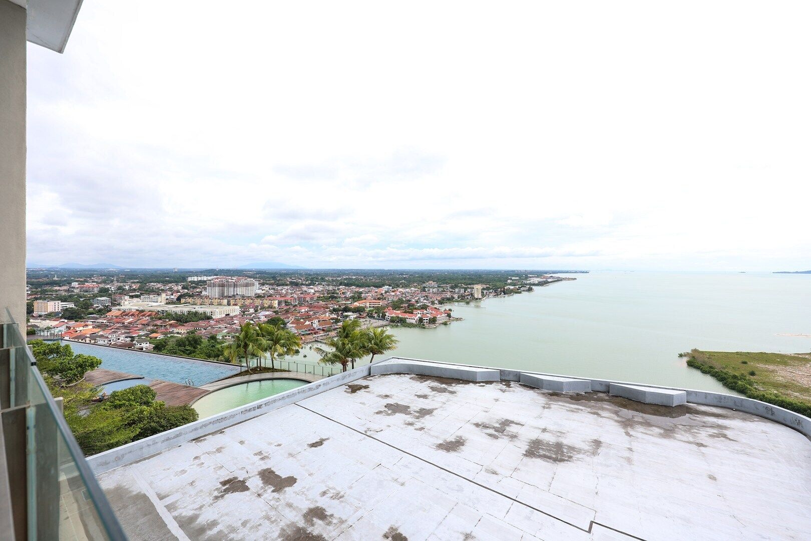 Varanda com vista para um horizonte costeiro, incluindo edifícios e um corpo de água.