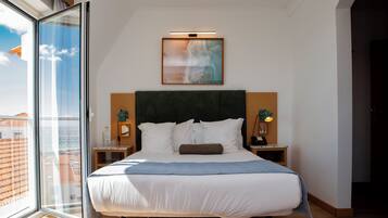 Quarto moderno com uma cama grande, vista através de uma porta de correr e um quadro acima da cama.