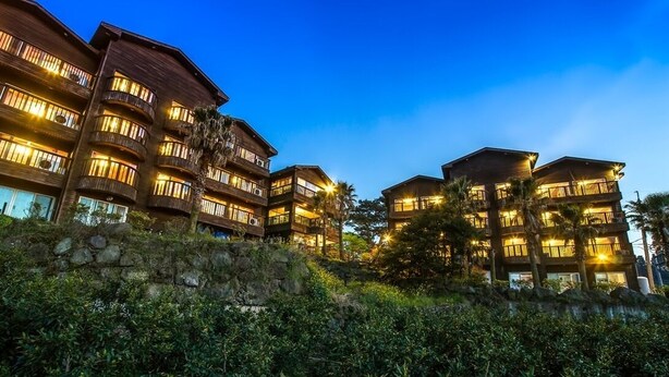 Um hotel de vários andares com varandas e iluminação acolhedora.