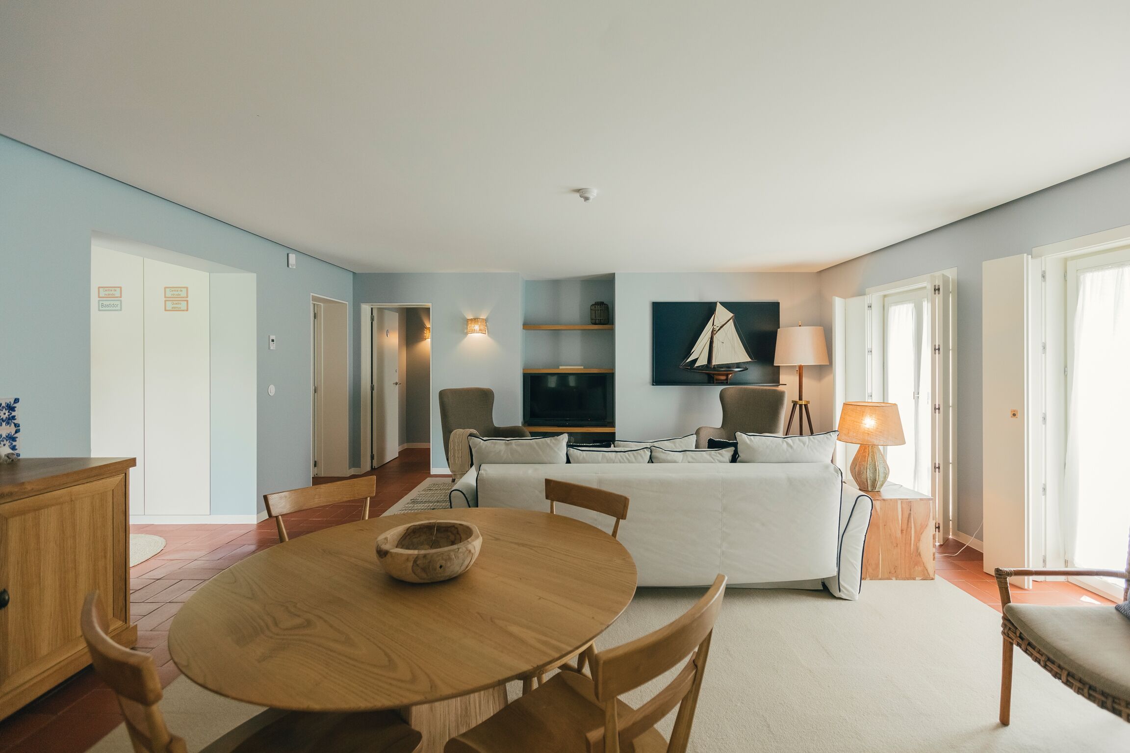 Uma sala de estar moderna com área de jantar, sofá e televisão.