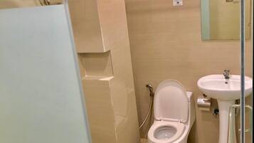 Quarto Twin Deluxe | Casa de banho | Um polibã, um chuveiro fixo, artigos de higiene pessoal grátis, um bidé