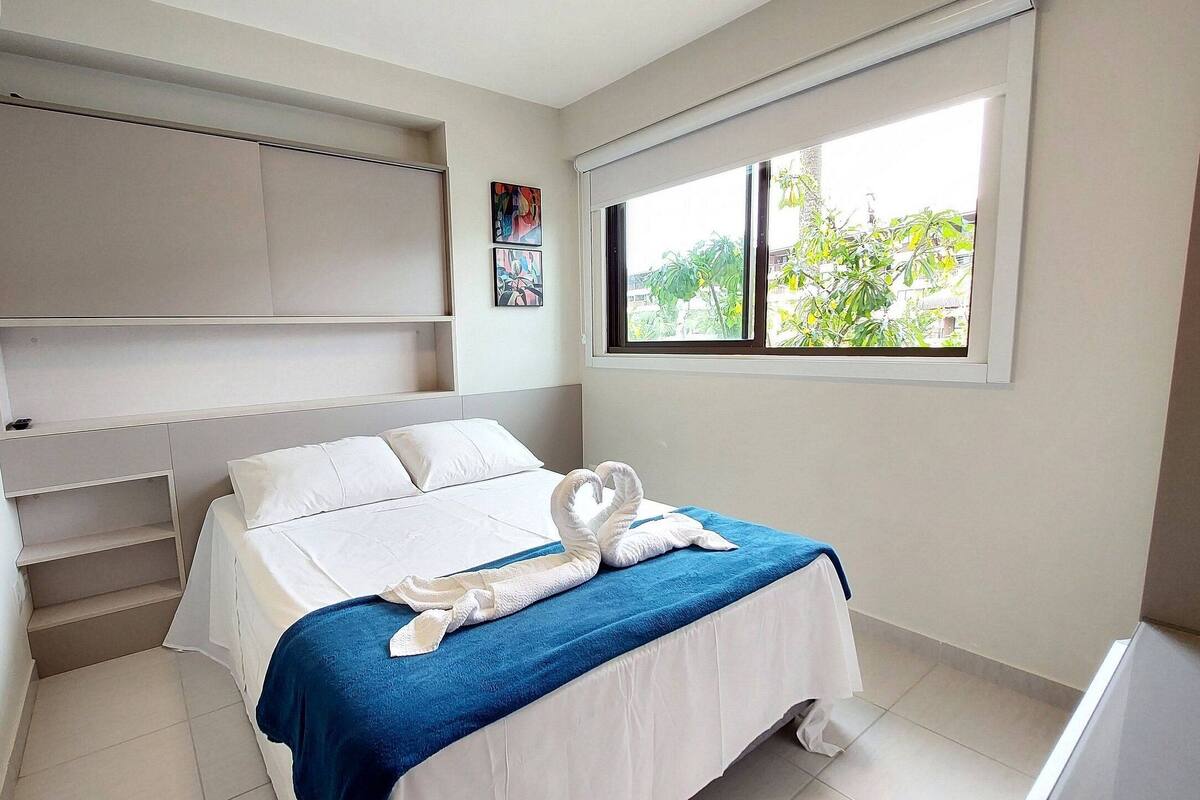 Quarto com cama, janela, guarda-roupa e prateleira.