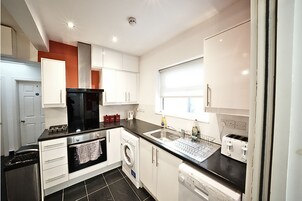 Um frigorífico, um micro-ondas, um forno, uma placa de cozinha 