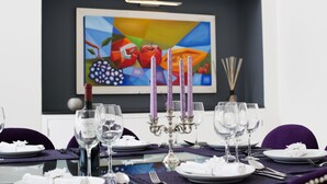 Uma mesa de jantar posta com taças de vinho, pratos e um candelabro.