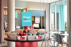 Exposição de produtos alimentares com um letreiro que diz 'Ótimo em todos os aspectos' em um ambiente interno moderno.