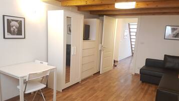 Um espaço de estar compacto com mesa de jantar, sofá e guarda-roupa.