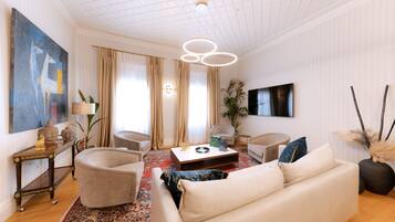 Uma sala de estar moderna com um sofá, cadeiras, uma mesa de centro e um quadro grande na parede.