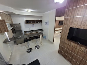 Uma cozinha moderna com forno embutido, geladeira de aço inoxidável, pia dupla e bancada de madeira.