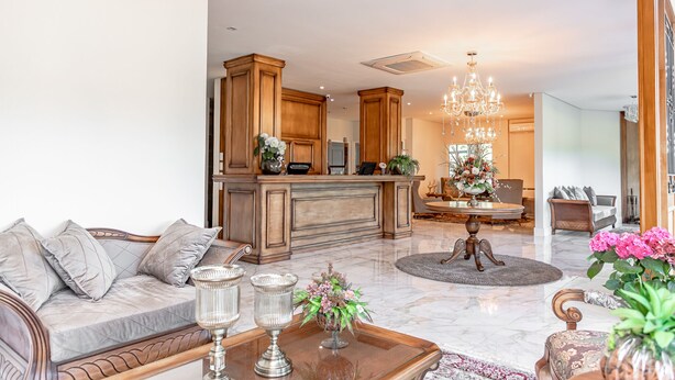 Uma sala de estar espaçosa com um sofá grande, uma mesa de centro e um objeto decorativo.