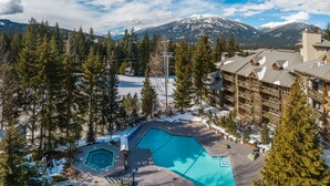 Um resort com área de piscina, teleférico e vista para as montanhas.