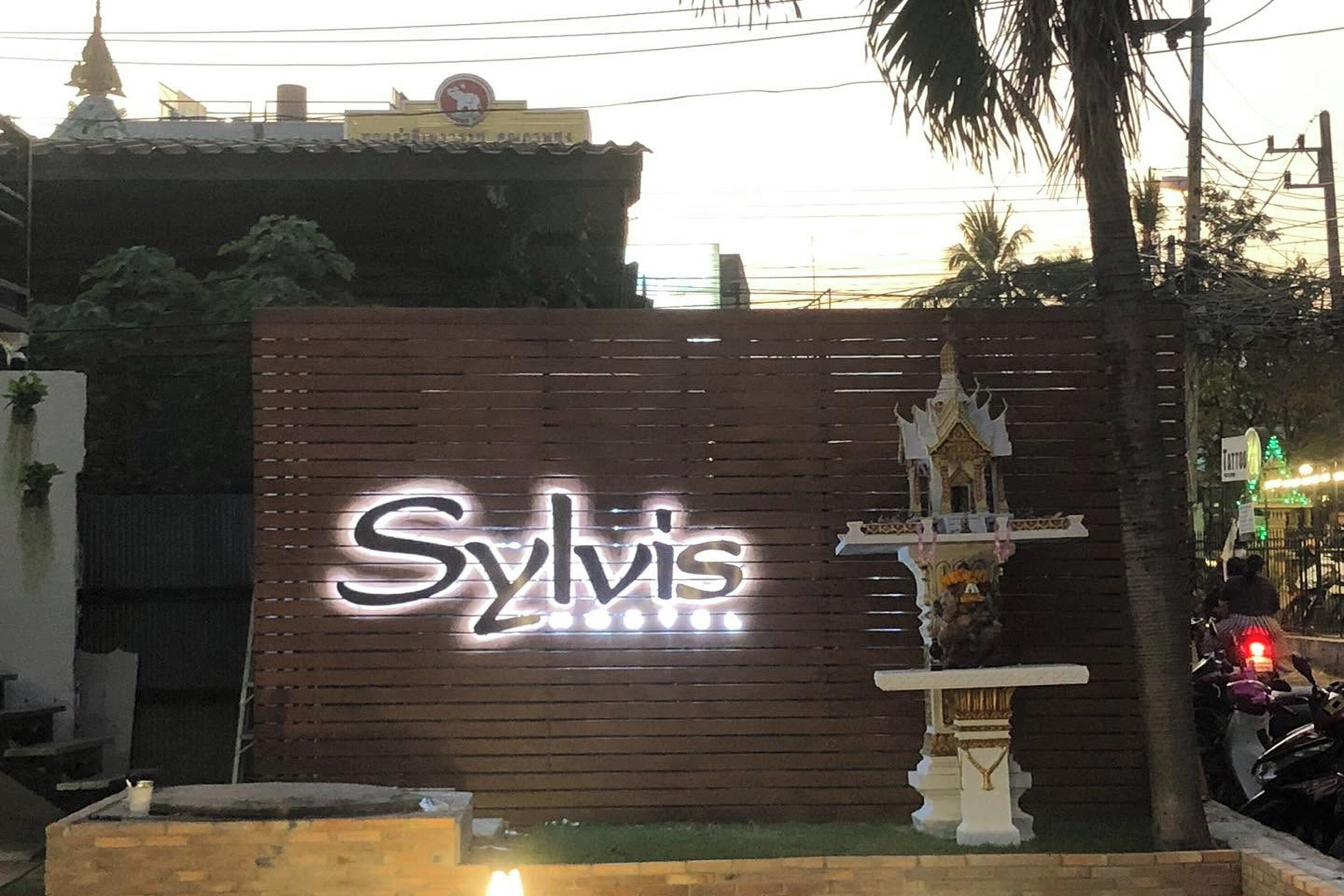 Um letreiro com o nome 'Sylvis' iluminado em letras brancas sobre um fundo escuro.
